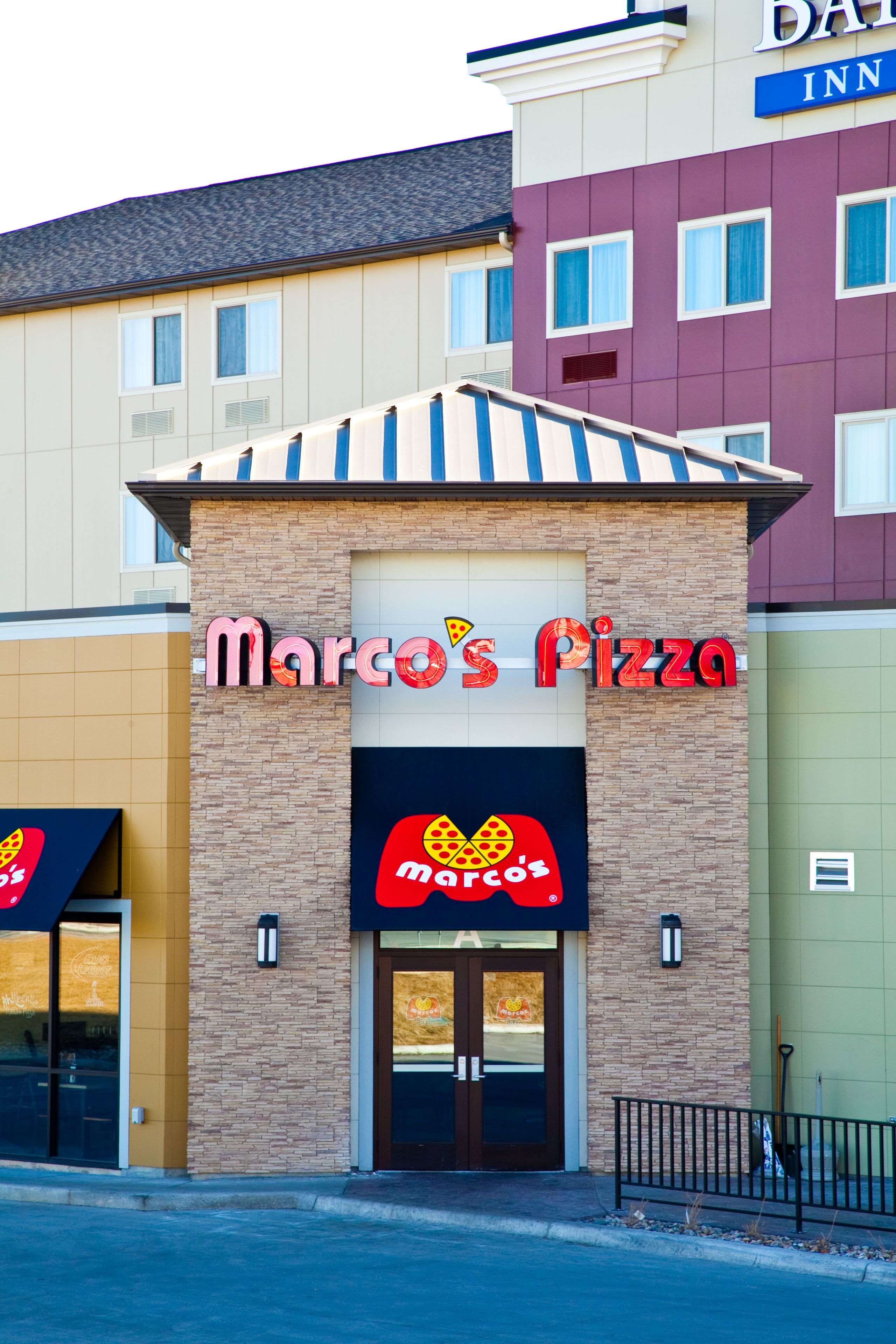 Um edifício com a placa da Marco's Pizza.