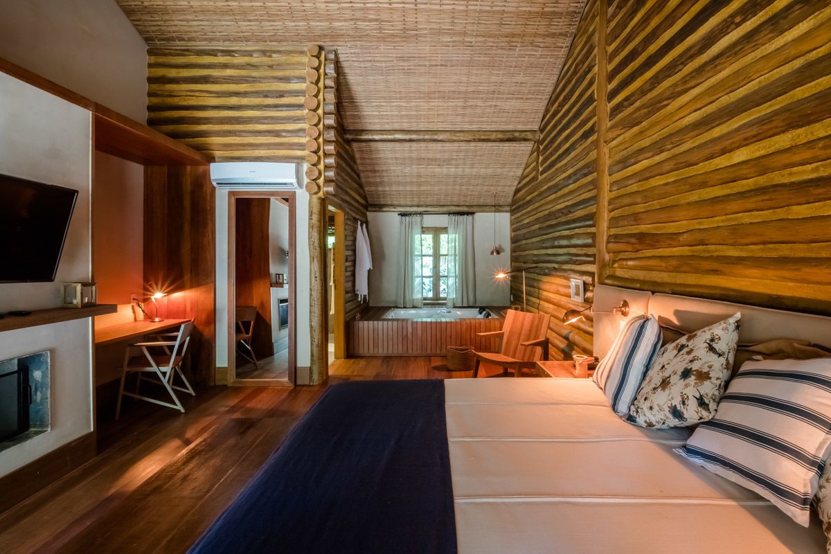 Quarto aconchegante com uma cama, uma escrivaninha e vista para uma cozinha e um banheiro.