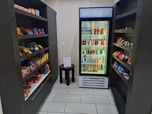 Uma loja de lanches com prateleiras repletas de petiscos e bebidas.