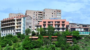 Um hotel de vários andares com fachada de vidro moderna, diversas varandas e um letreiro com a inscrição 