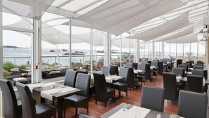 Restaurante com área externa e vista para o mar.