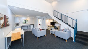 Um apartamento moderno com sala de estar, cozinha e escada.
