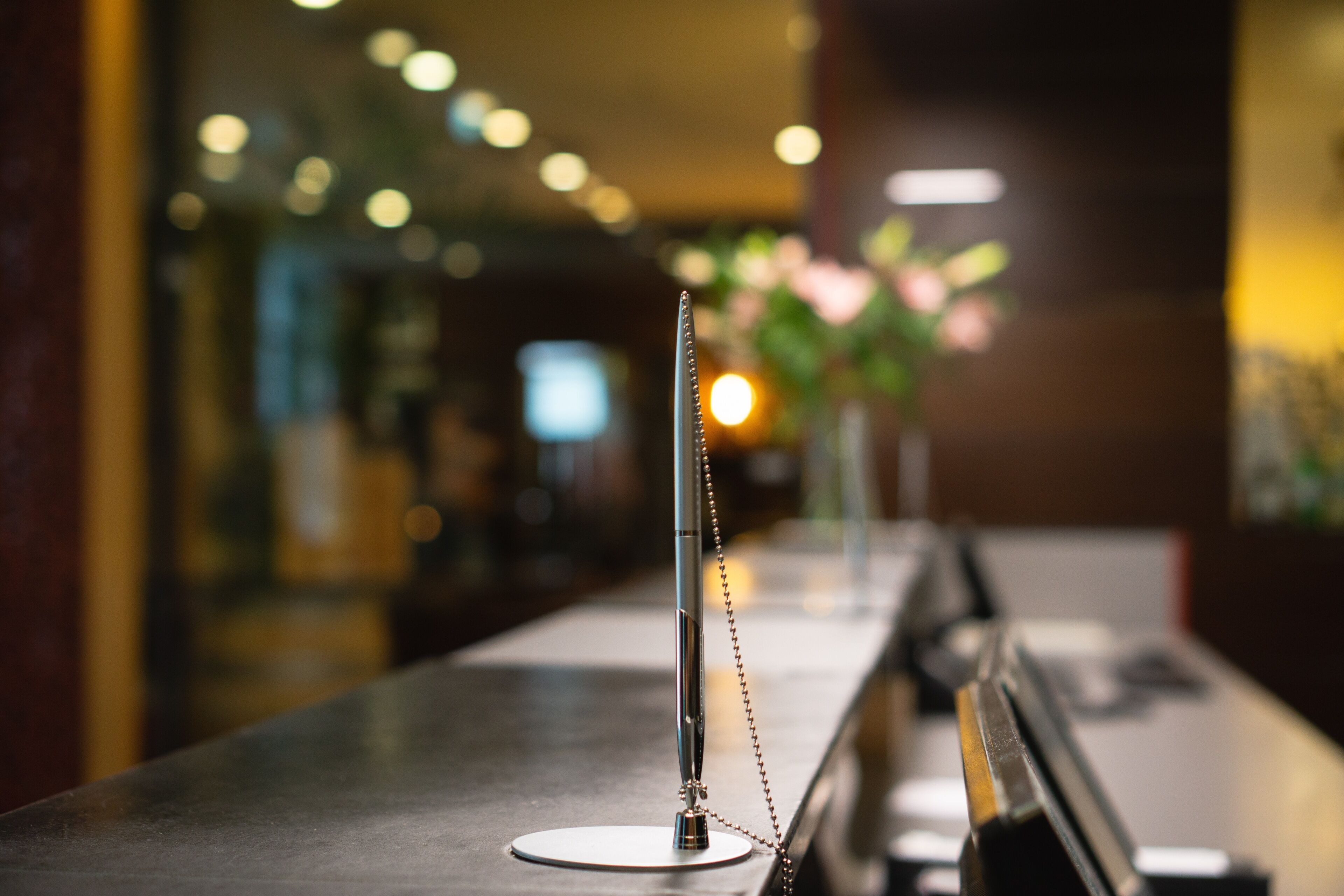 Balcão de bar com porta-canetas e uma barreira de corrente.
