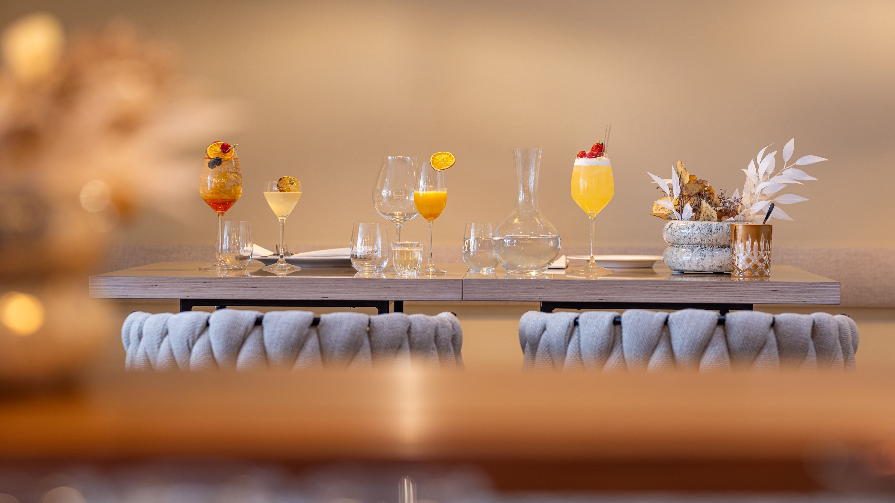 Uma mesa de jantar com diversos copos e um vaso decorativo.
