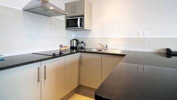 Suite, 1 quarto, vista parcial para o mar | Kitchenette privada | Um frigorífico, um micro-ondas, uma placa de cozinha