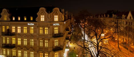 Um hotel com estilo arquitetônico europeu clássico, apresentando varandas ornamentadas e janelas amplas.