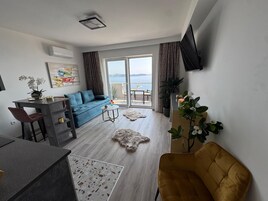 Apartamento Deluxe, 2 quartos, varanda, vista para o mar | Sala de estar | Televisor 