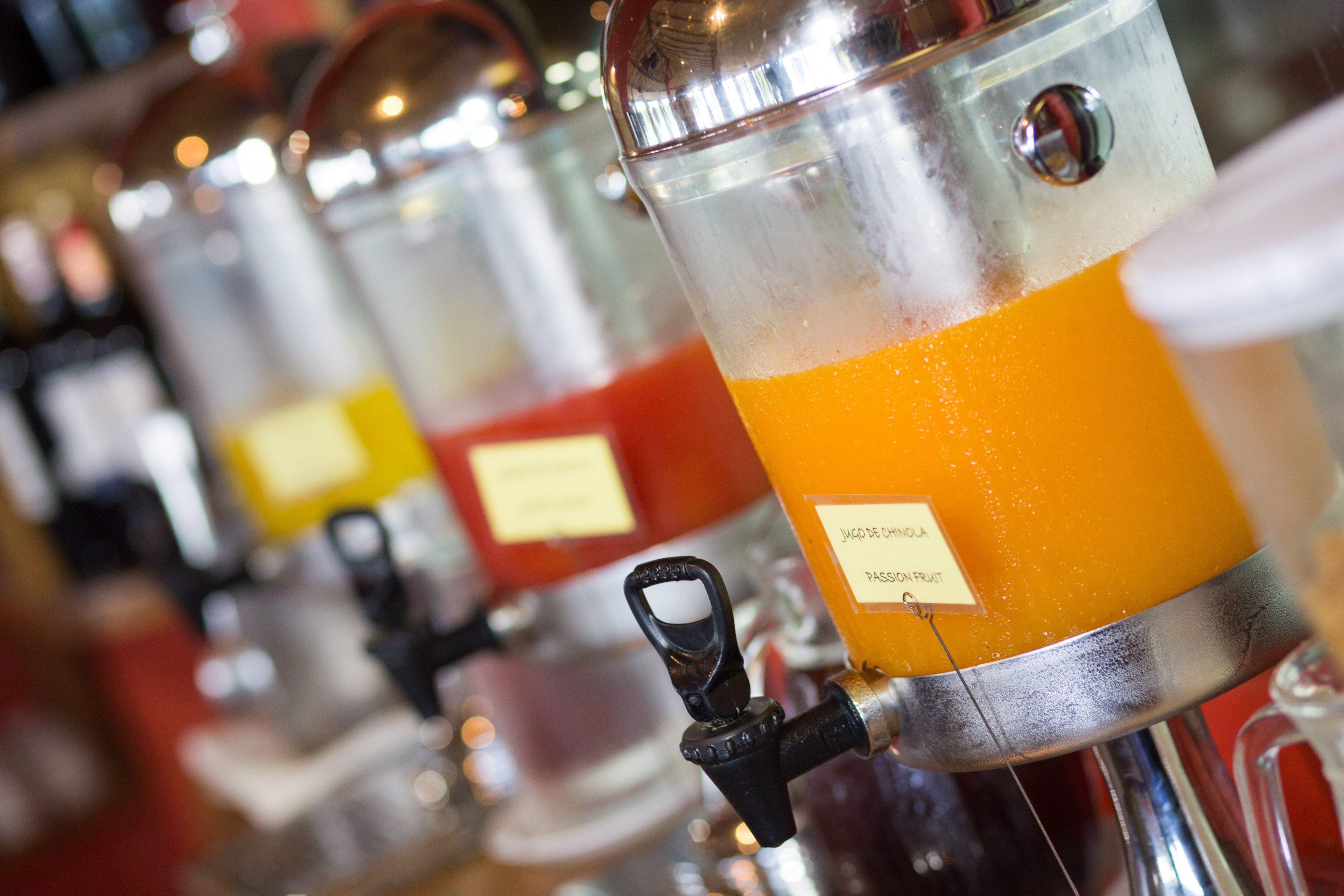 Uma fileira de dispensadores de bebidas com etiquetas mostrando diferentes sabores.