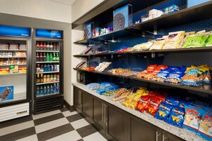 Um bar com bebidas refrigeradas, salgadinhos e biscoitos.