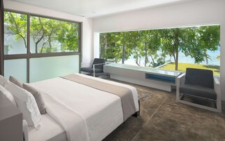 Um quarto moderno com uma janela grande, uma cama, uma escrivaninha e uma cadeira.