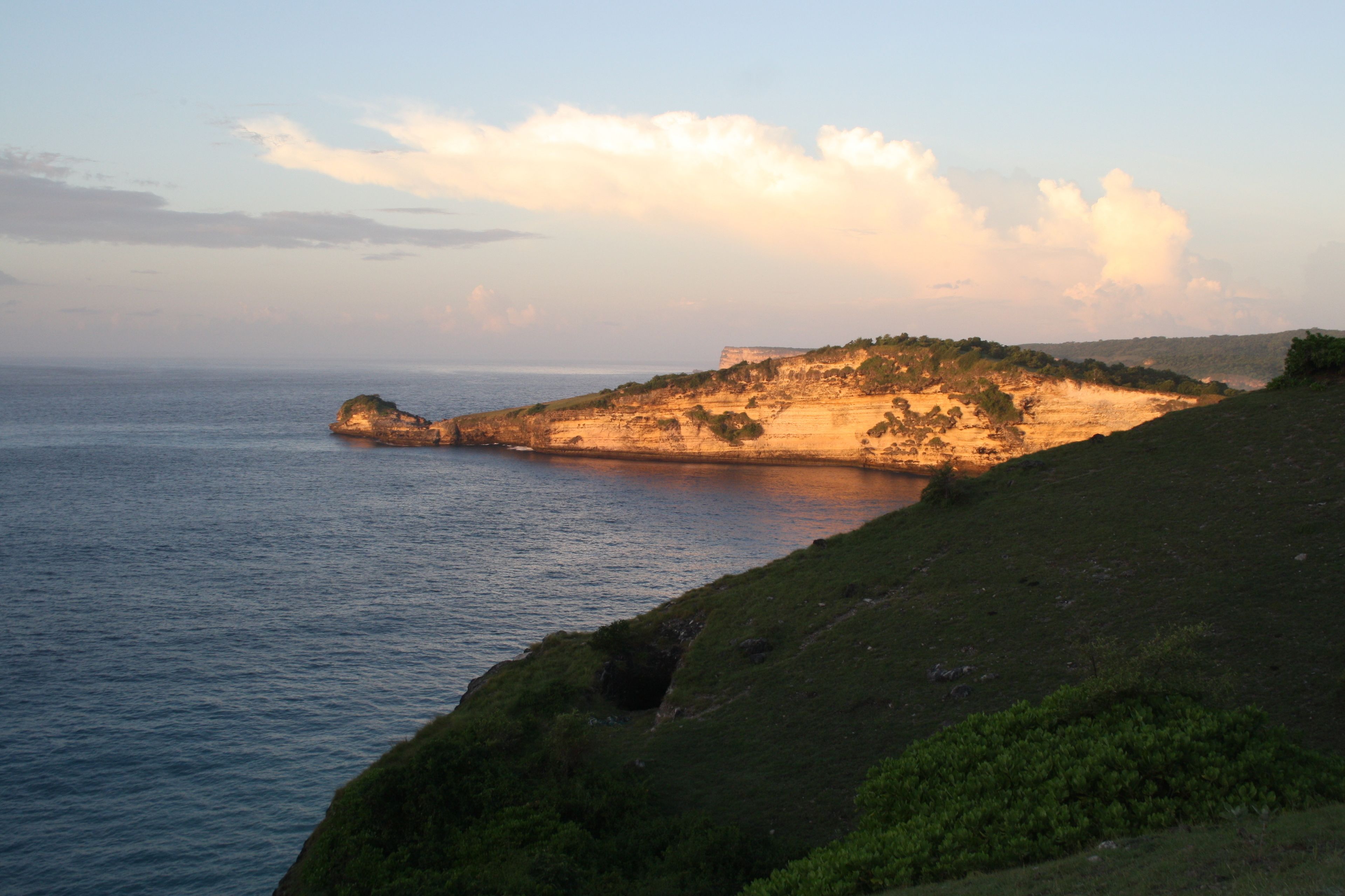 Paisagem costeira com falésias e vista para o mar.