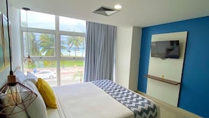 Quarto de hotel com cama, televisão e vista para o exterior.
