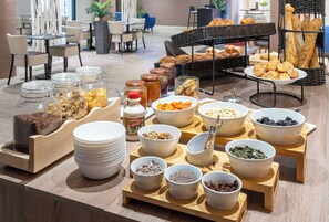 Disposição de buffet com diversos alimentos e acompanhamentos.
