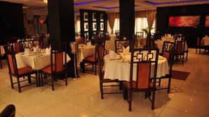 Um restaurante com mesas redondas, cadeiras de madeira escura e design de interiores moderno.