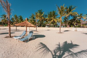 Praia particular, espreguiçadeiras, guarda-sóis 