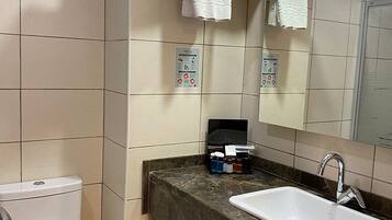 Uma casa de banho moderna com sanita, lavatório e porta-toalhas.