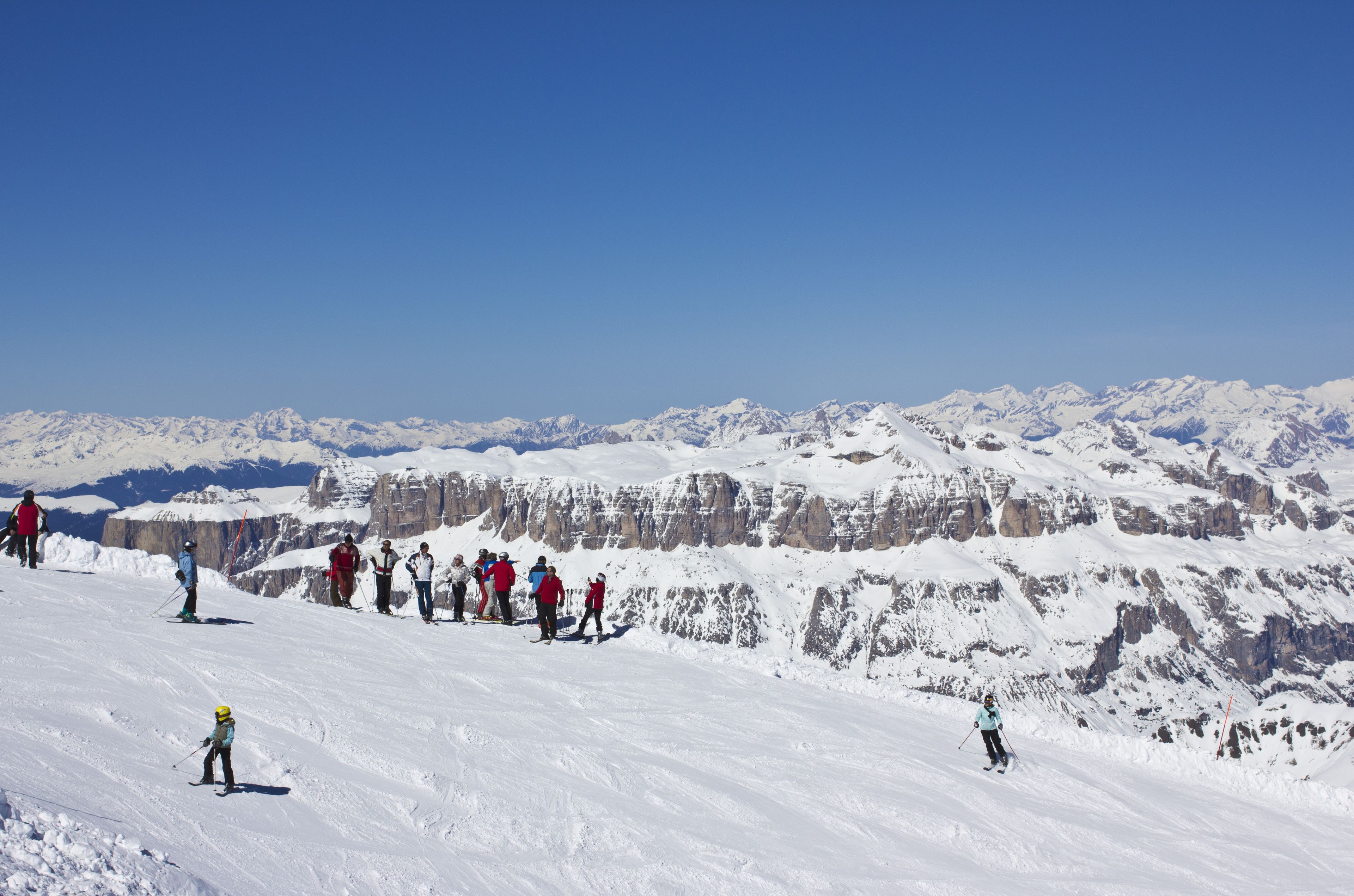 Paisagem nevada de montanha com esquiadores e snowboarders.