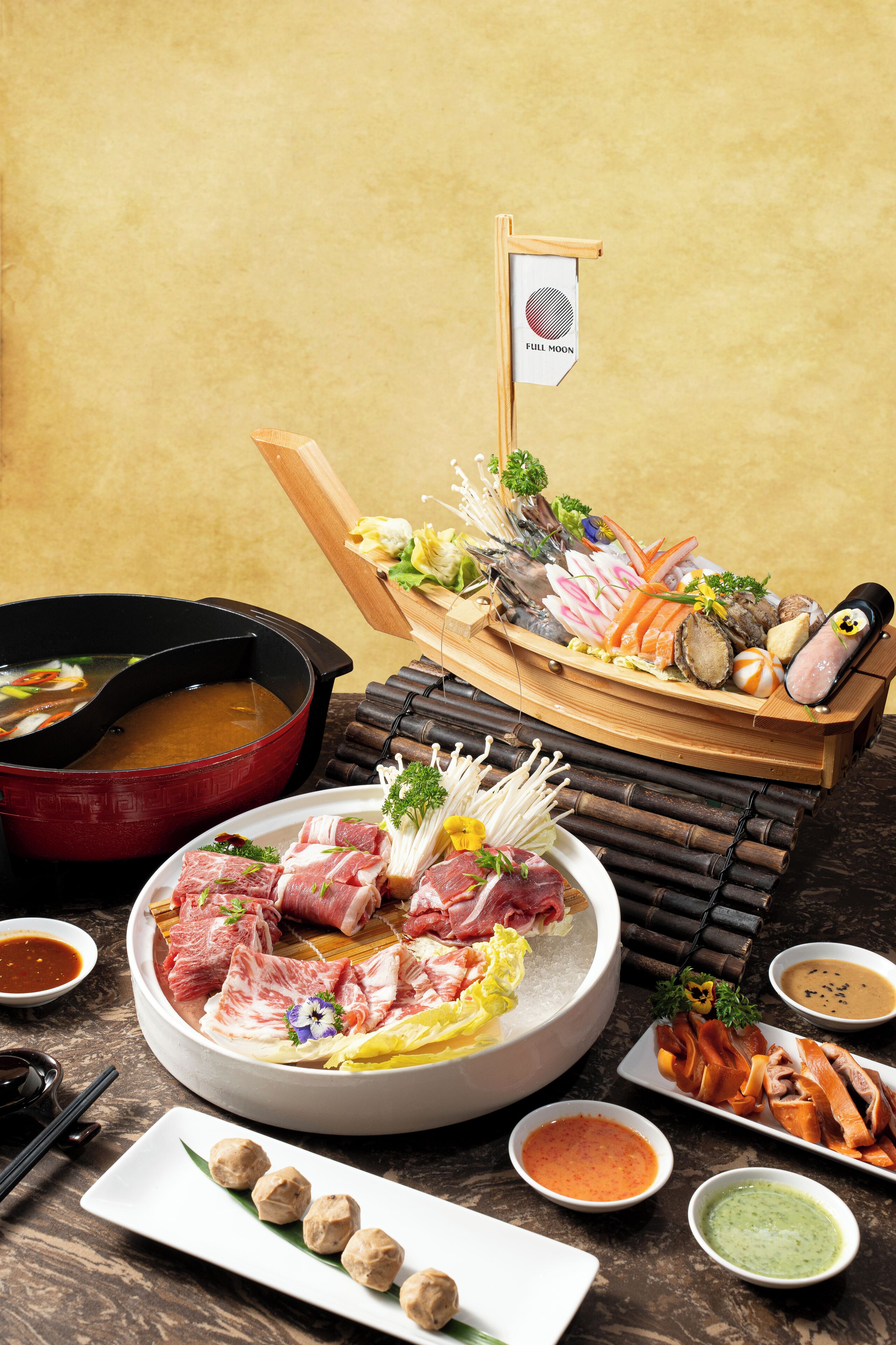 Montagem de um prato de panela quente com diversos tipos de carne e vegetais, uma panela vermelha e uma mesa de madeira.