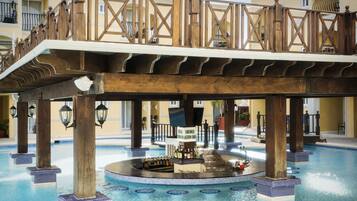 Uma área de piscina com bar sob uma ponte de madeira, sustentada por colunas, e piso de azulejos ao redor da piscina.