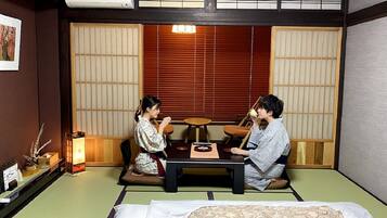 Um quarto japonês tradicional com tatames, uma mesa baixa e portas shoji.