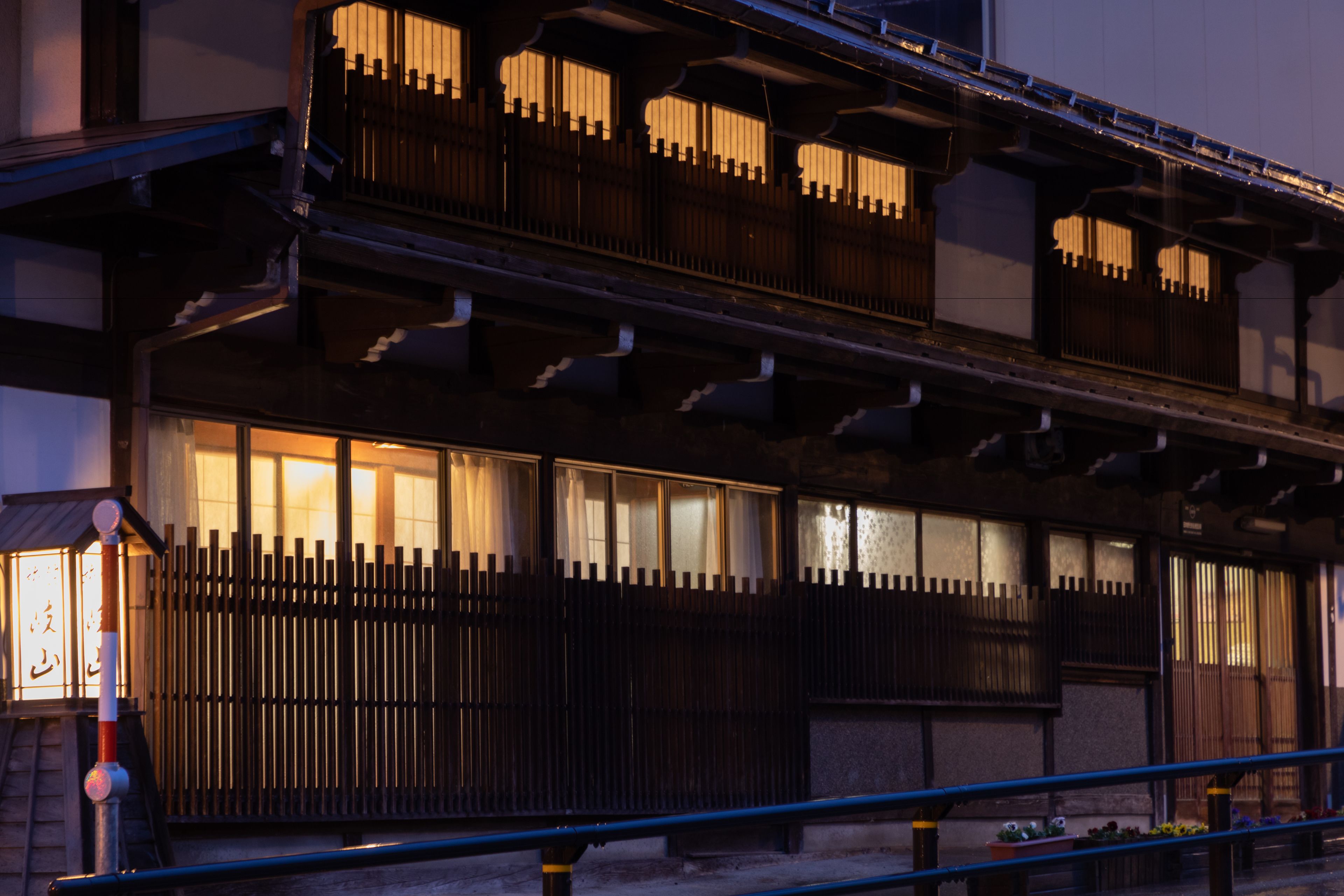 Um edifício japonês tradicional com várias janelas e varanda de madeira.