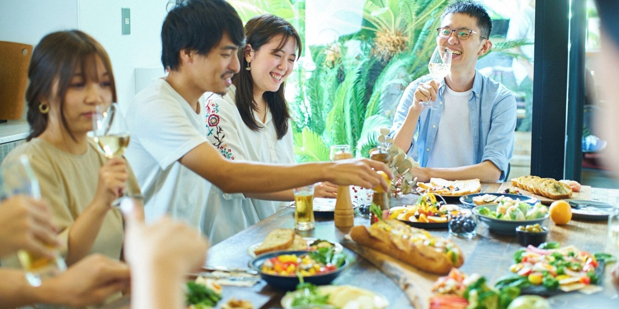 Um grupo de pessoas jantando à mesa, com diversos pratos e bebidas.