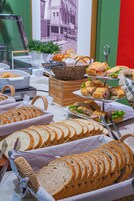 Buffet com diversos pães e sanduíches.