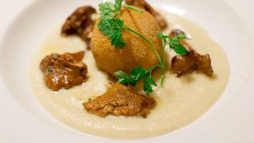 Um prato com molho cremoso, guarnecido com salsa e pedaços de carne.