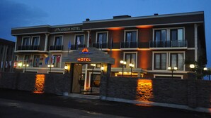 Hotel com fachada moderna, várias varandas e entrada destacada com uma placa.