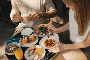 Uma mesa de jantar com diversos pratos, incluindo uma salada, uma torta de fruta e uma xícara de café.