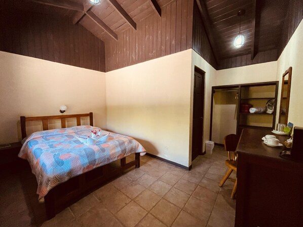 Quarto com cama, escrivaninha e cadeira.