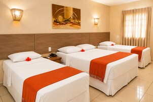 Quarto de hotel com três camas, cabeceira de madeira, um quadro na parede e uma janela com cortinas.
