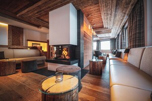 Uma sala de estar moderna com lareira, piso de madeira e sofá de couro.