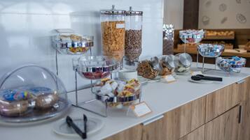 Um buffet de café da manhã com diversos alimentos e acompanhamentos.
