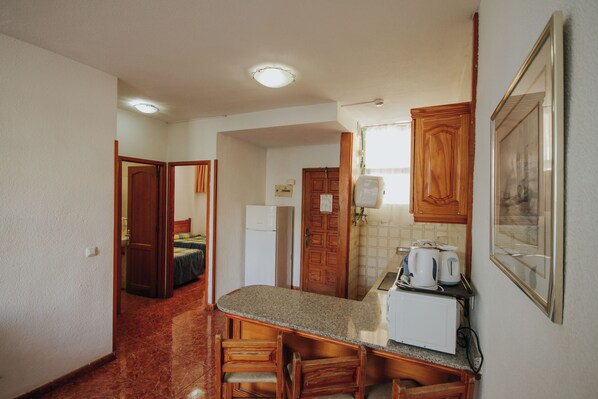 Um frigorífico, um micro-ondas, uma cafeteira/bule