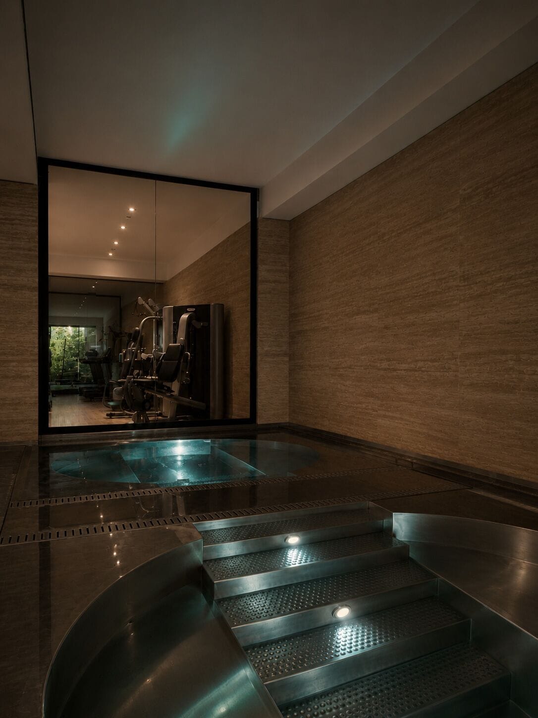 Uma área de spa moderna com piscina envidraçada, sauna e sala de ginástica.