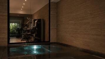 Uma área de spa moderna com piscina envidraçada, sauna e sala de ginástica.