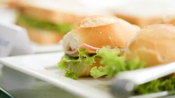 Um sanduíche em um prato branco com alface e pão.