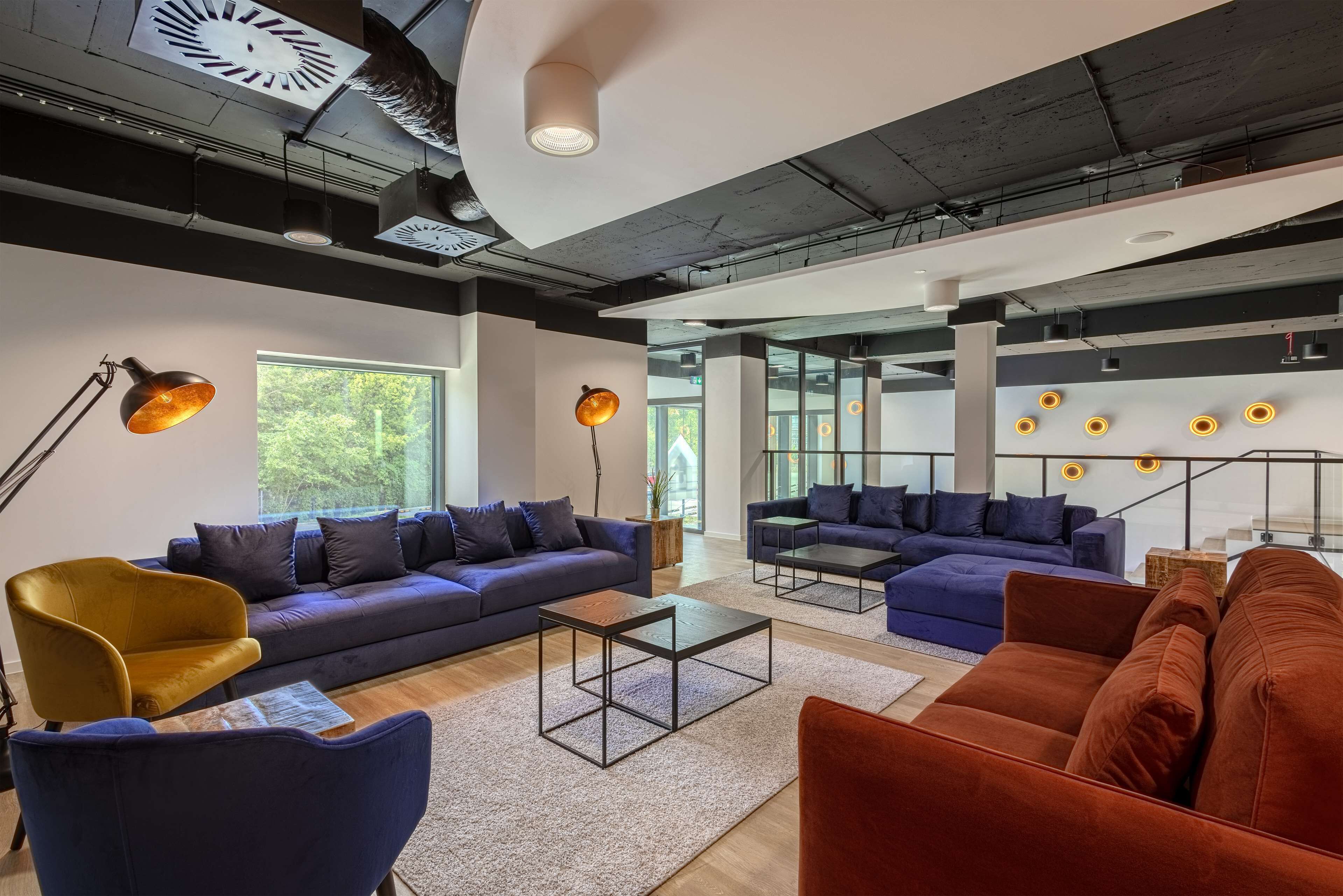 Uma sala de estar moderna com um sofá modular, uma mesa de centro e uma poltrona amarela.