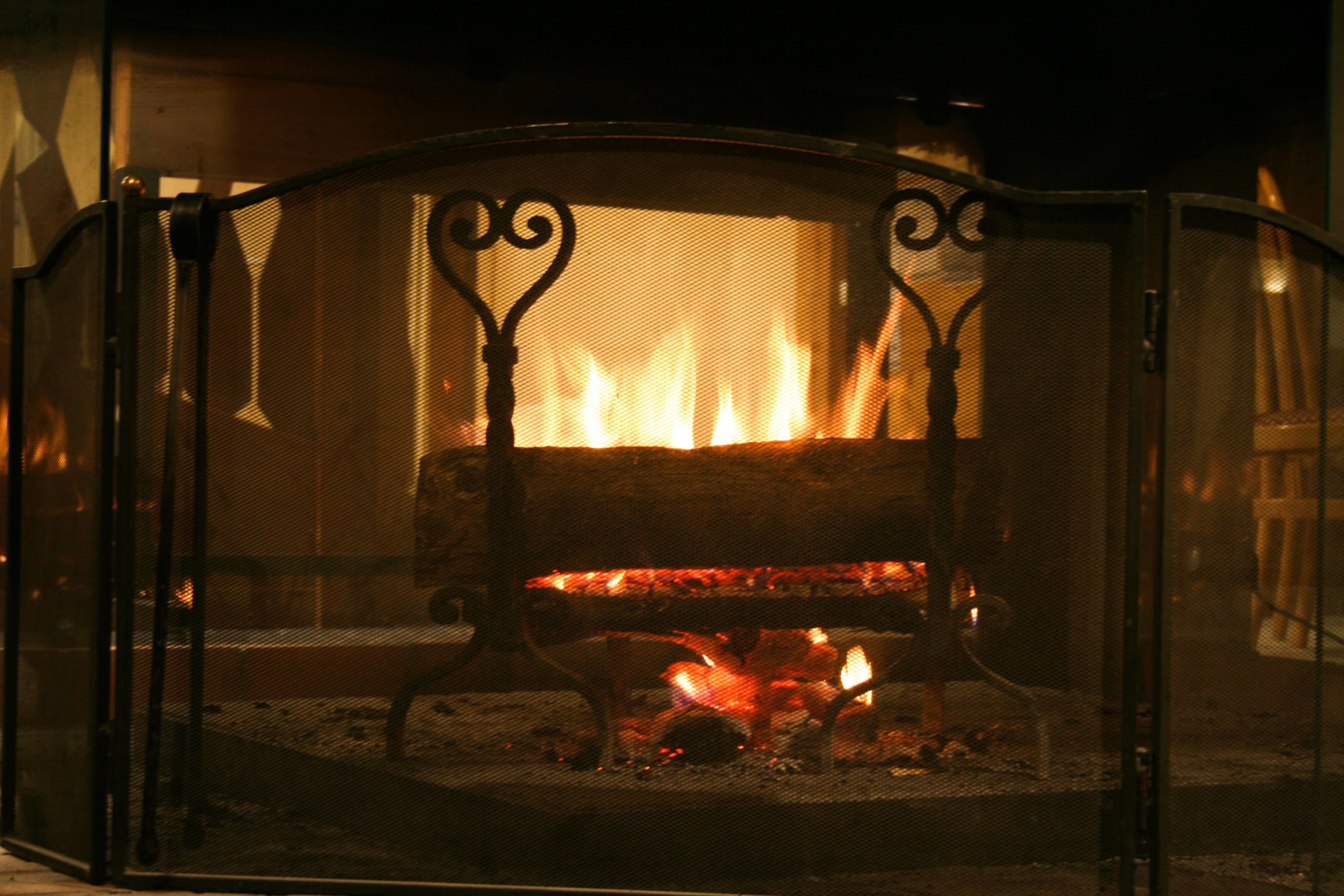 Uma lareira com proteção de metal e detalhes em ferro decorativo.
