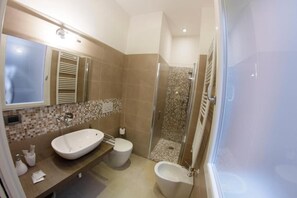 Quarto triplo conforto, suíte | Banheiro | Chuveiro, secador de cabelo, bidê, toalhas de banho