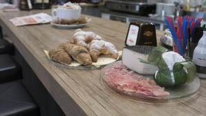 Uma mesa de café da manhã com croissants, queijo e presunto.