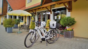 Um hotel com fachada amarela, telhado de telhas vermelhas e uma bicicleta estacionada na frente.