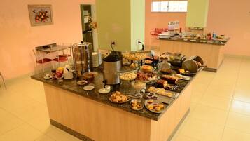 Buffet com diversas opções de comida e um espaço para café.