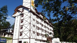 Um hotel com vários andares e um design arquitetônico marcante, com uma torre imponente e diversas janelas.