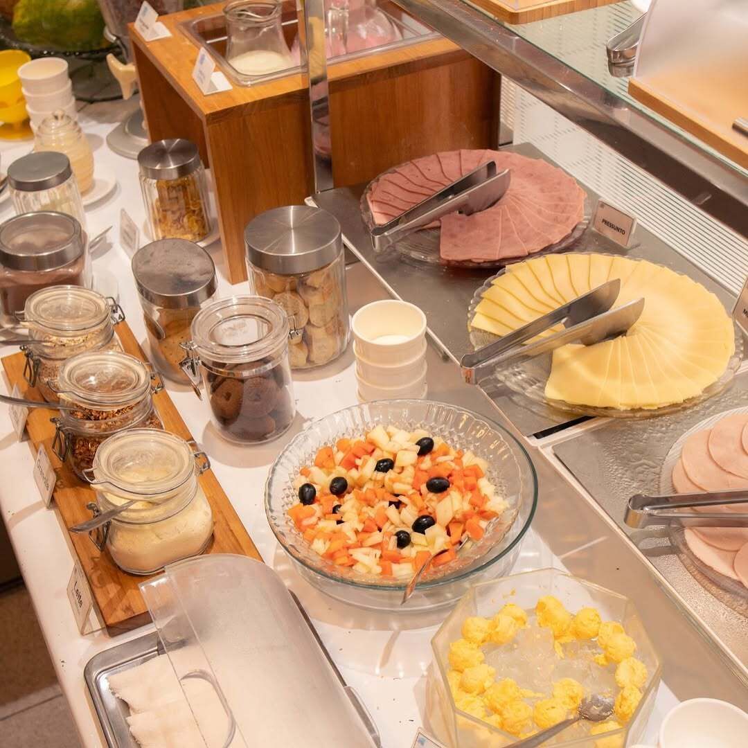 Buffet com diversos alimentos e utensílios.