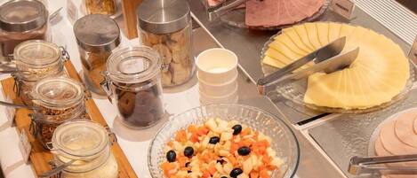Buffet com diversos alimentos e utensílios.