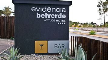 Placa do Hotel Evidência Belverde Attitude, com símbolo de bar e classificação de quatro estrelas.
