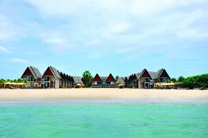 Na praia, areia branca, barracas de praia de cortesia, espreguiçadeiras