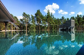 Piscina transparente com escada e grade de metal.